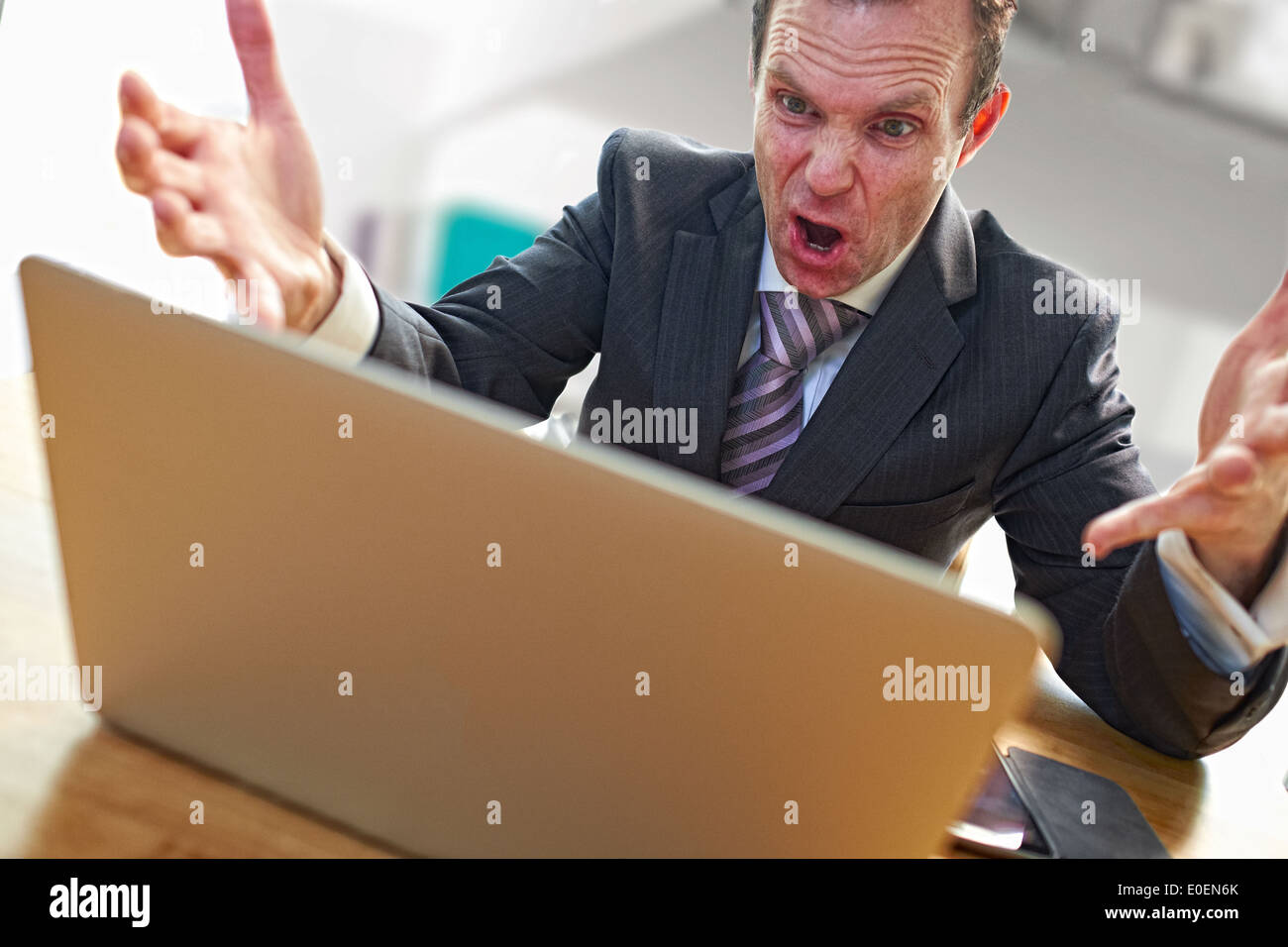 An angry businessman frustrated with problems with his laptop Stock ...