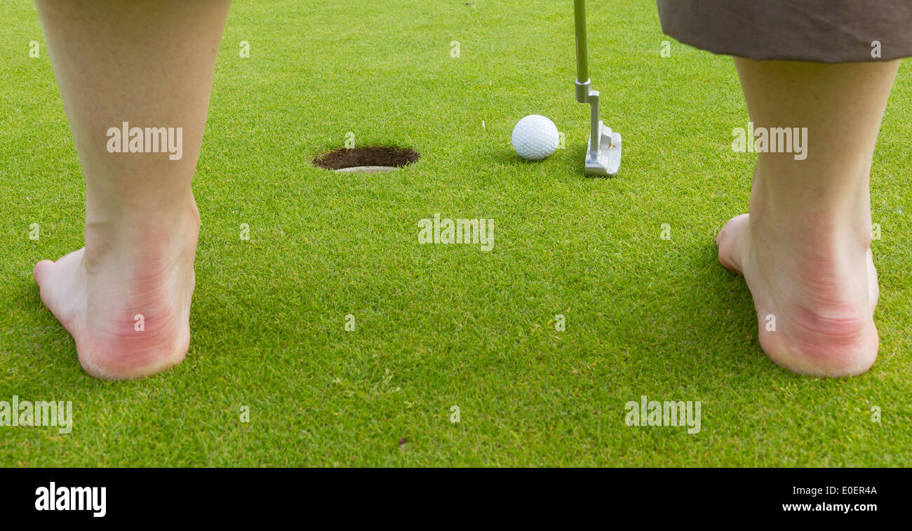Golf player hitting the ball close-up on whole (barefoot Stock Photo ...