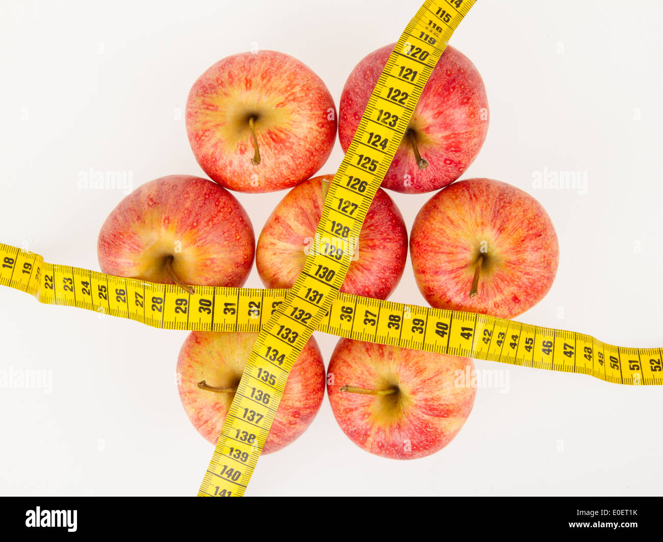Apple diet, red apples with a yellow tape-measure Stock Photo - Alamy
