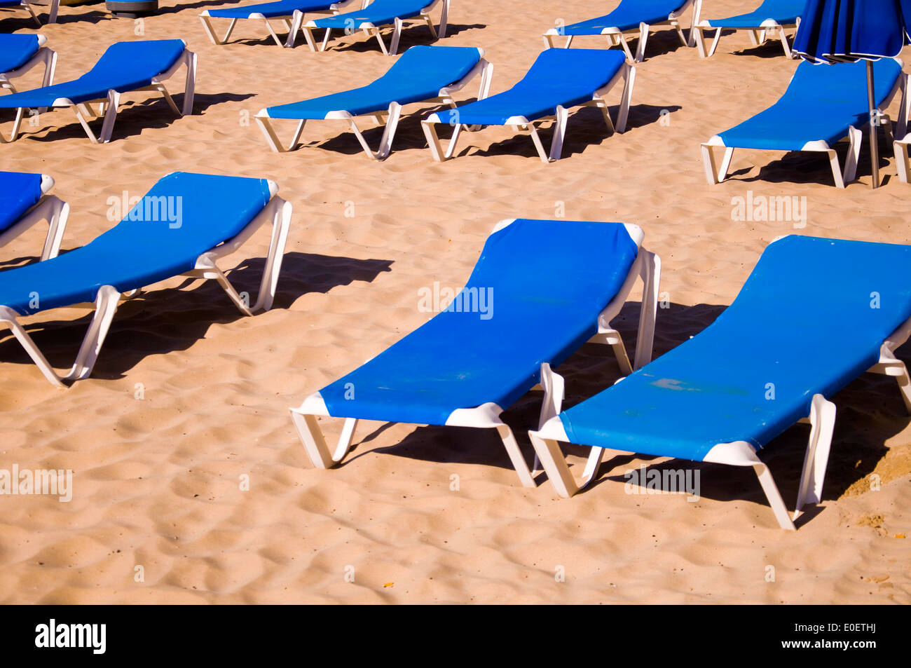 Blue sunbeds in the sand Stock Photo - Alamy