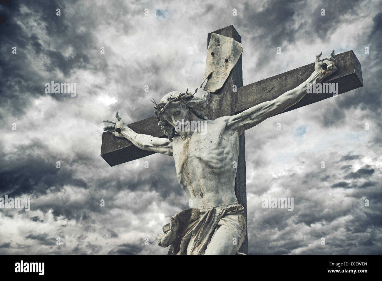 Crucifixion. Christian cross with Jesus Christ statue over stormy clouds. religion and ...
