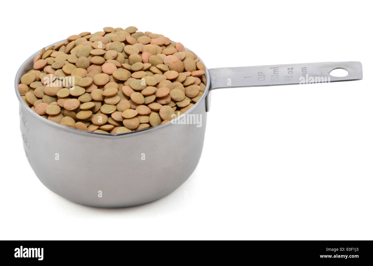 Green lentils in an American cup measure, isolated on a white ...