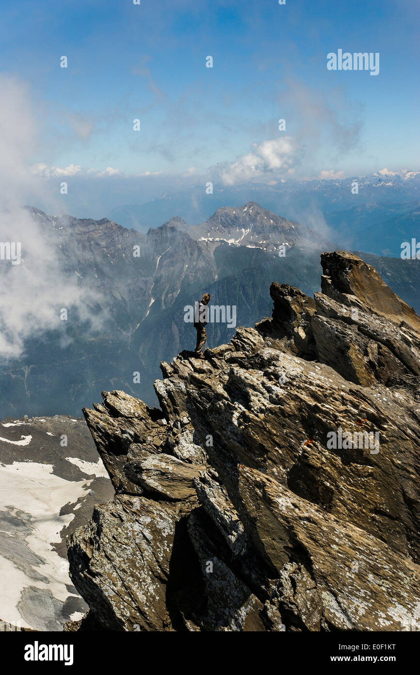 A man walks along the sharp summit ridge of the Haute Cime peak of the ...