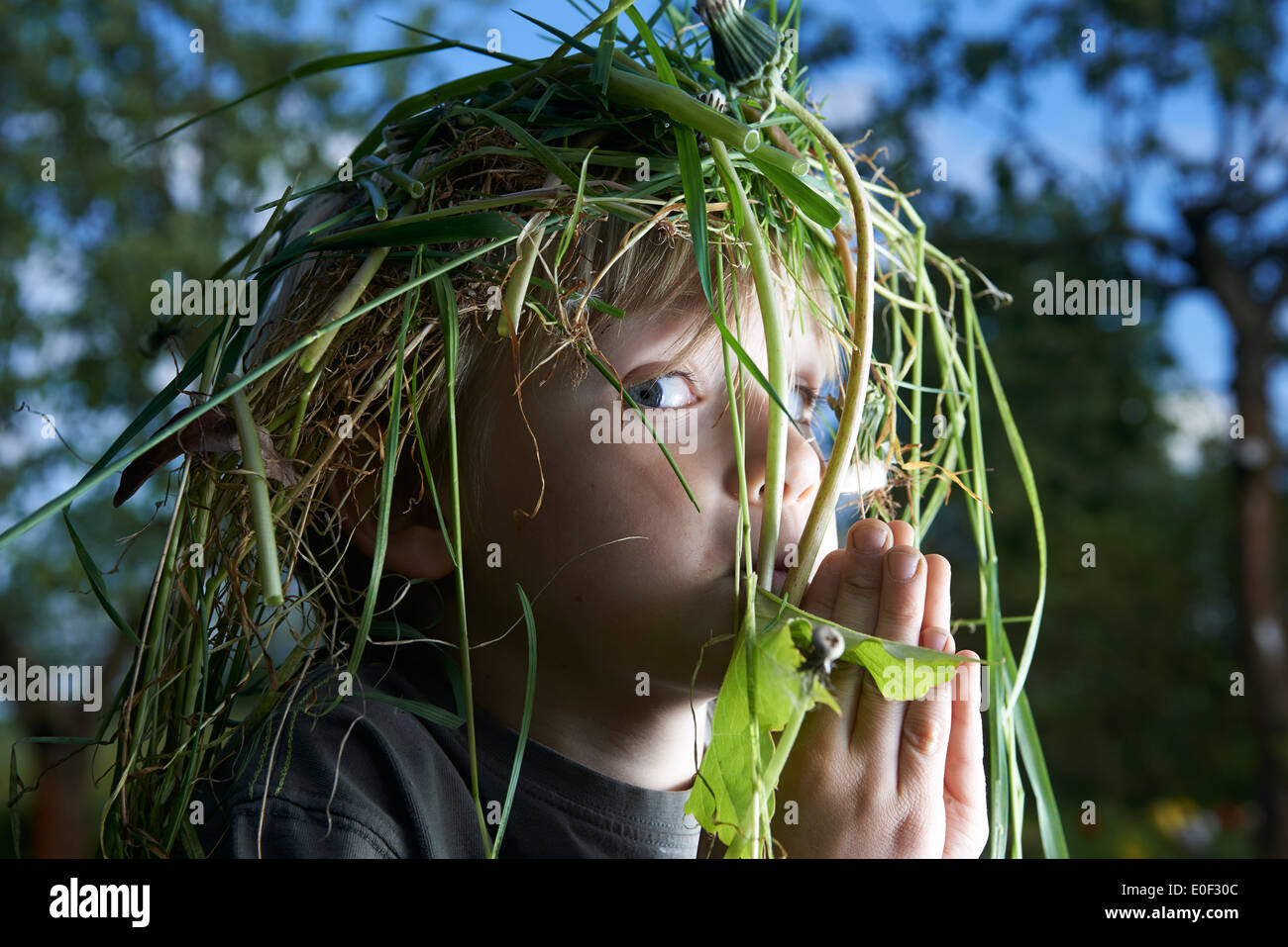 A Portrait of Child blond boy with grass on his head, making fun Stock ...