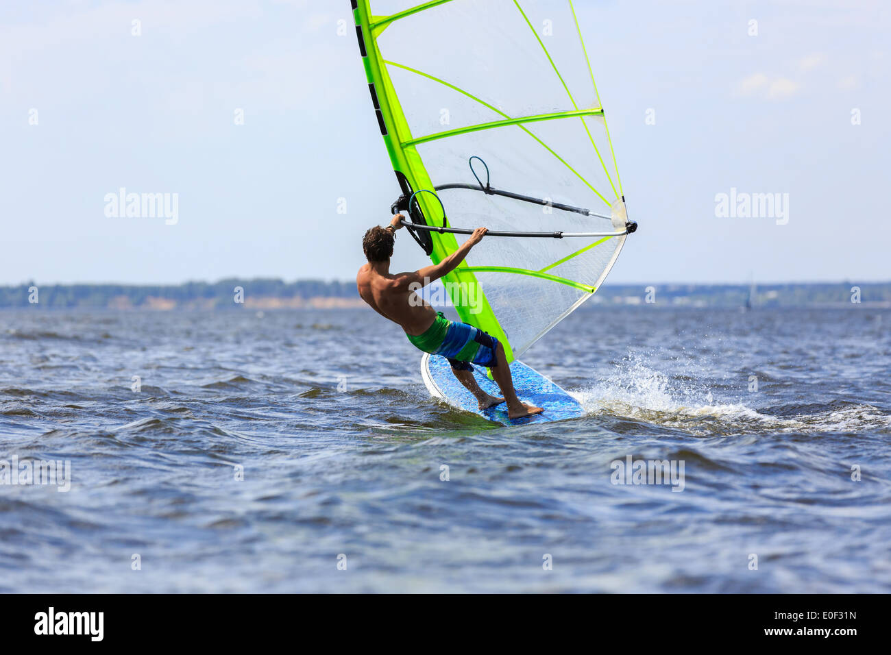Rear view of man windsurfing in splashes of water Stock Photo - Alamy