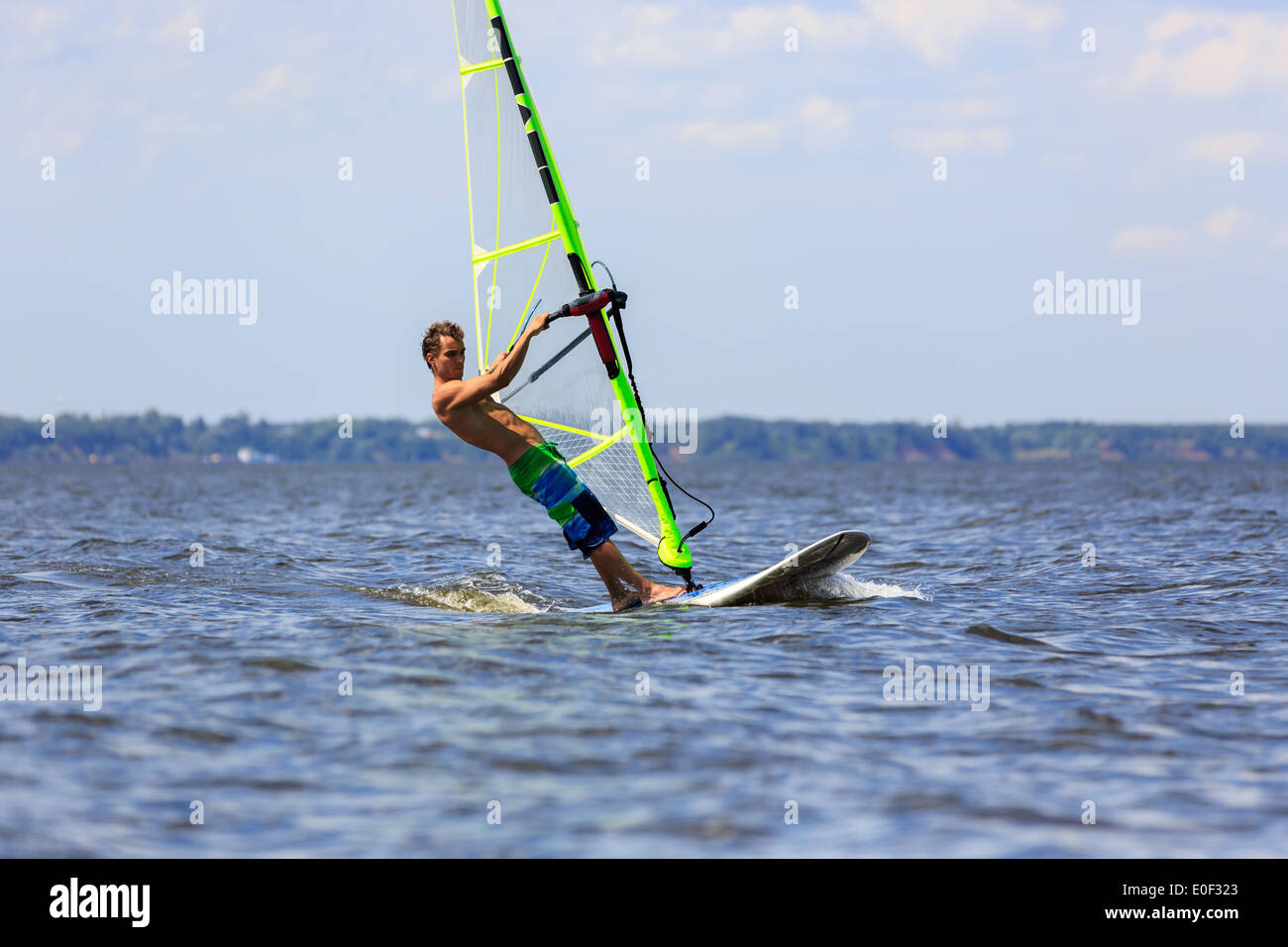 Front view of young man surfing the wind on summer day Stock Photo - Alamy