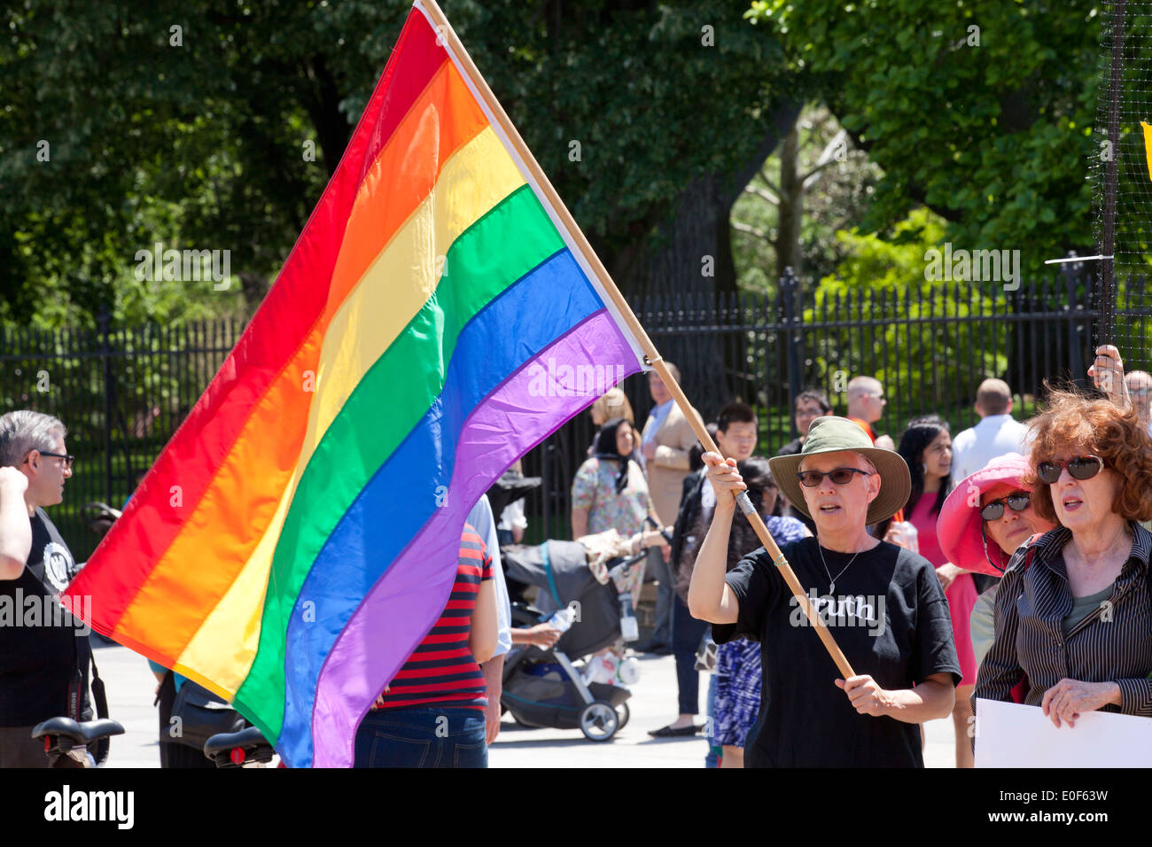 Person holding a rainbow flag at LGBT rally - Washington, DC USA Stock ...