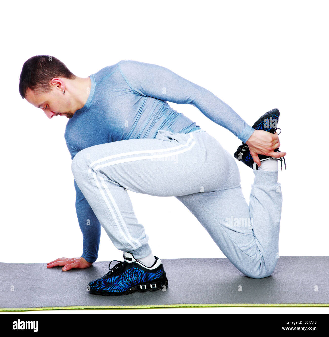 Sports man stretching over white background Stock Photo - Alamy