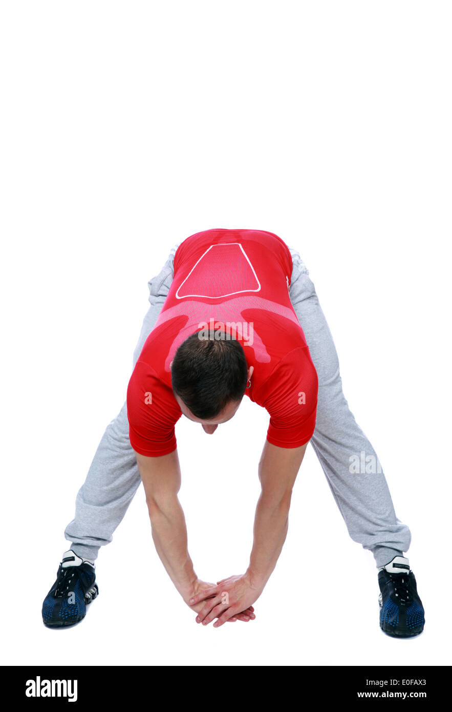 Sports man doing physical exercise for stretching over white background ...
