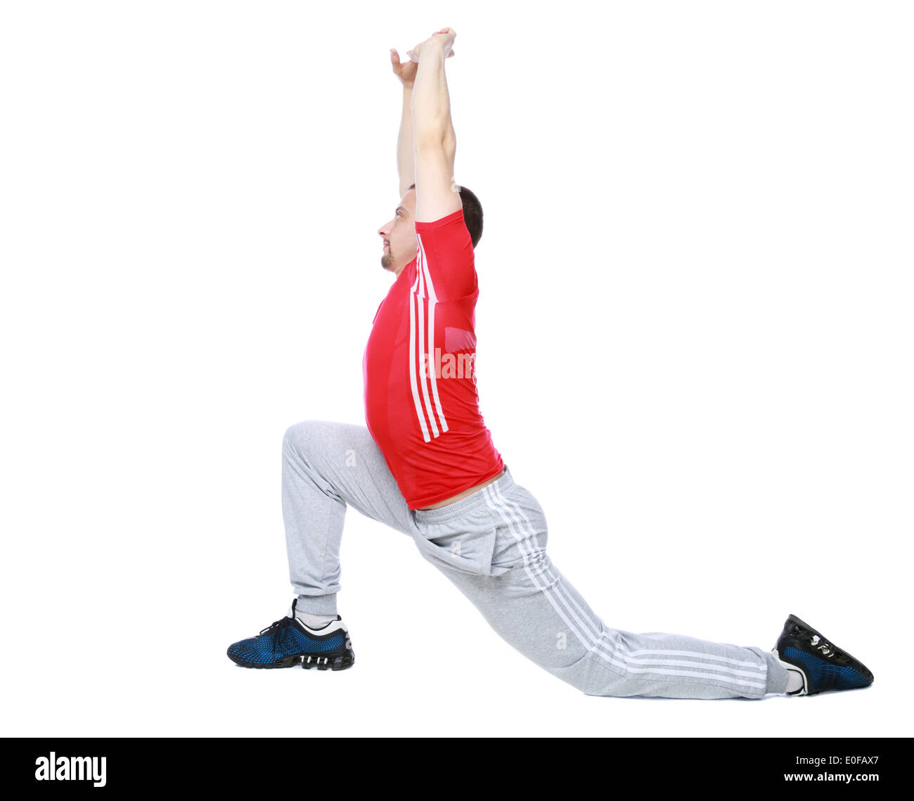 Sports man doing physical exercise for stretching over white background ...