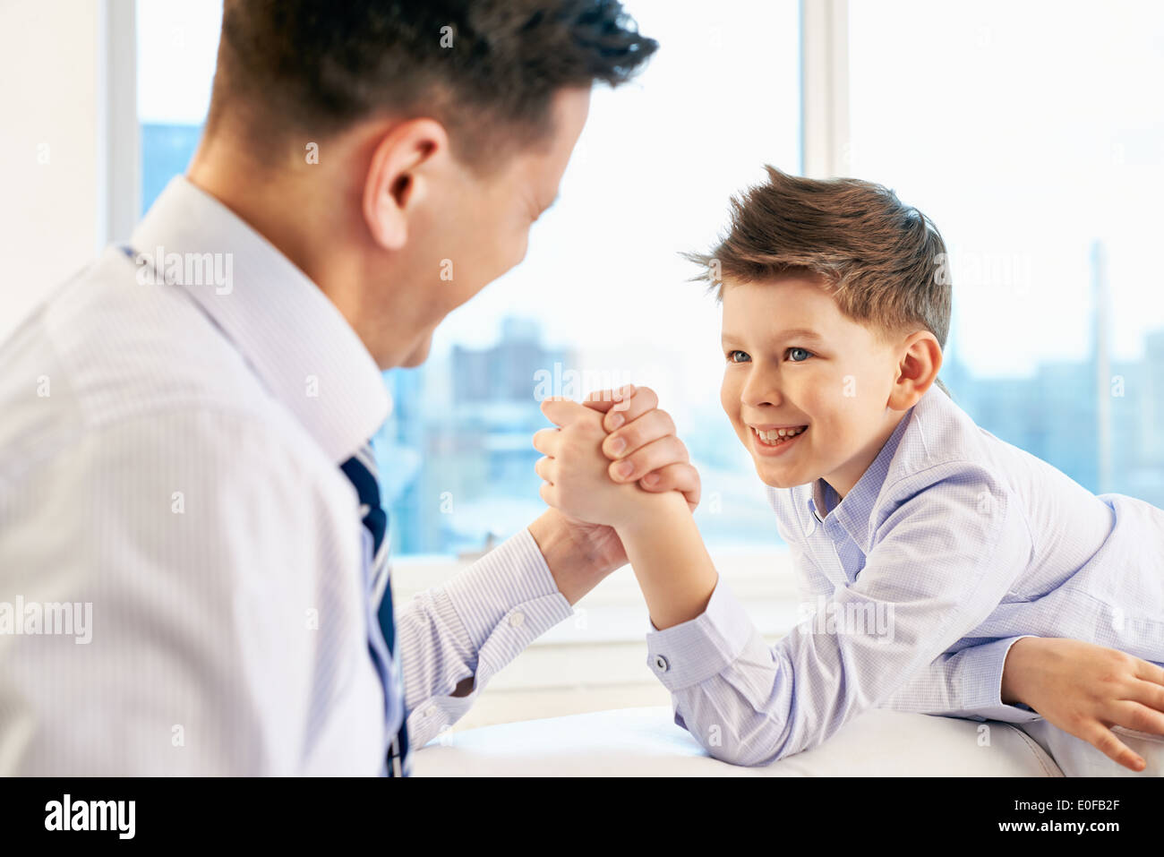 Photo of little boy and his dad competing in physical strength Stock ...