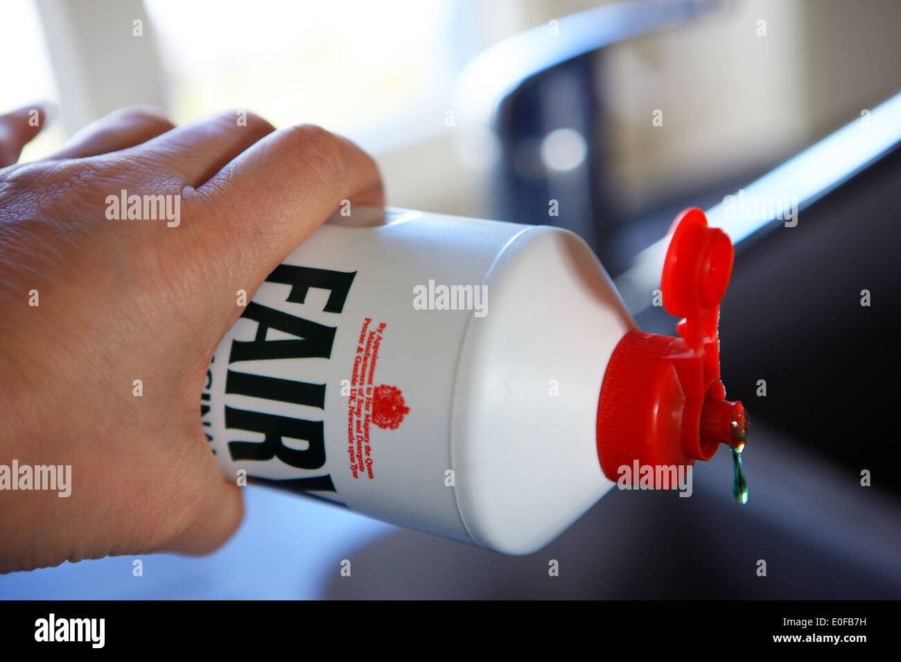 Hand pouring fairy washing up liquid into the sink Stock Photo - Alamy