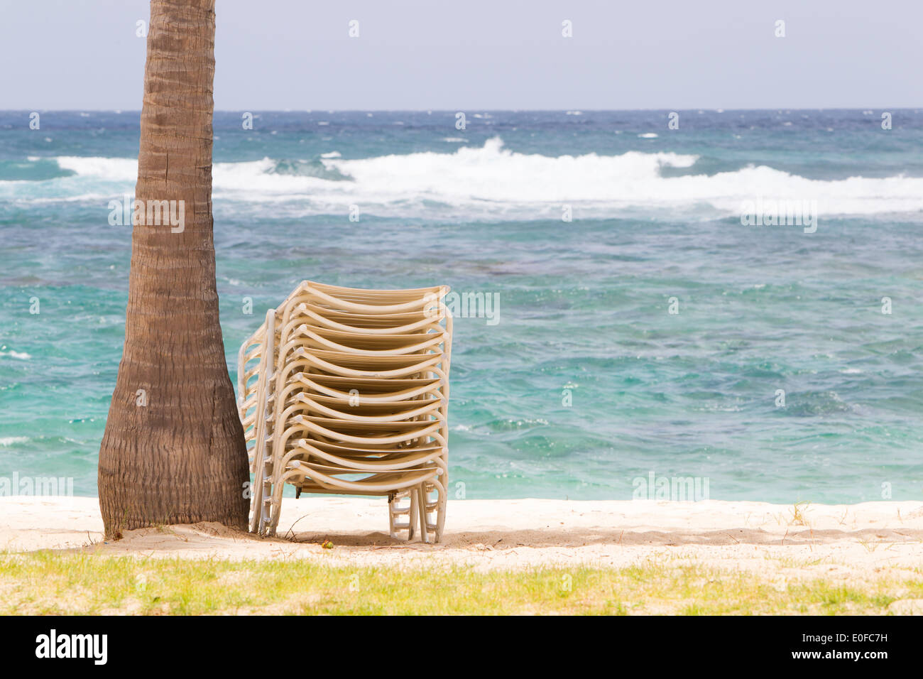 Stack of beach chairs under palm tree on idyllic tropical white sand ...