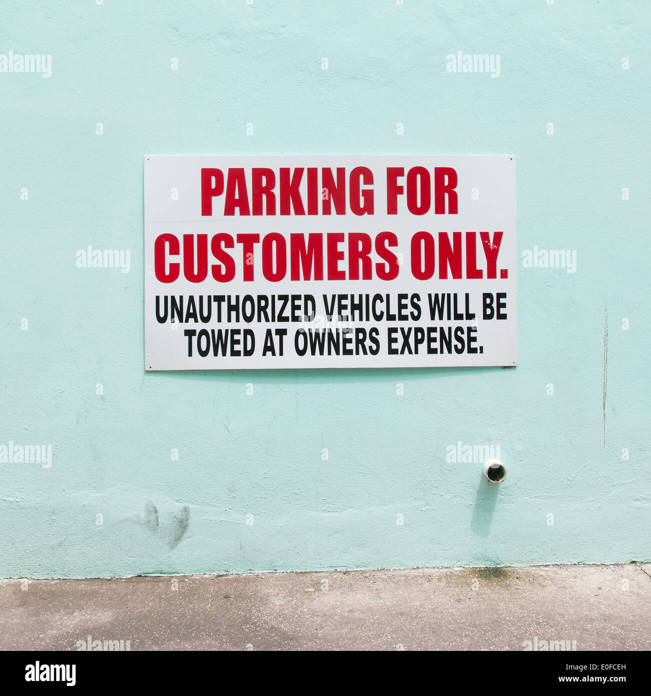 Customer parking only sign on a blue wall Stock Photo - Alamy