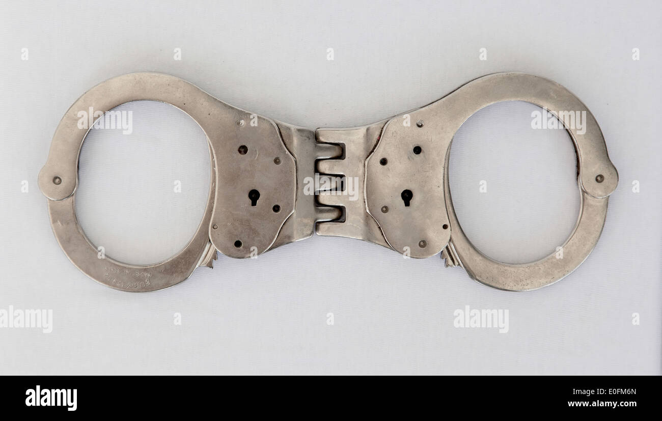 Modern metal handcuffs isolated, used and locked Stock Photo - Alamy