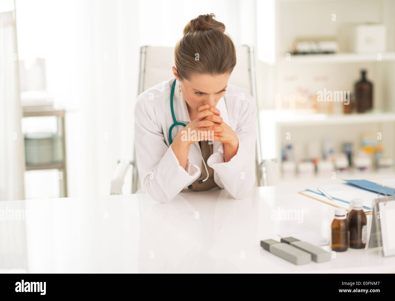 Concerned medical doctor woman sitting in office Stock Photo - Alamy