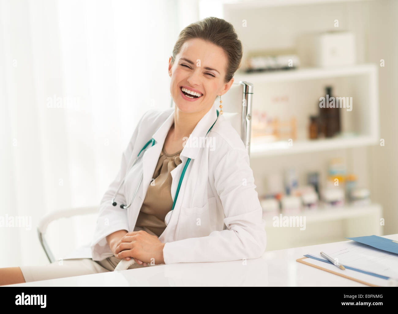 Portrait of laughing medical doctor woman sitting in office Stock Photo ...