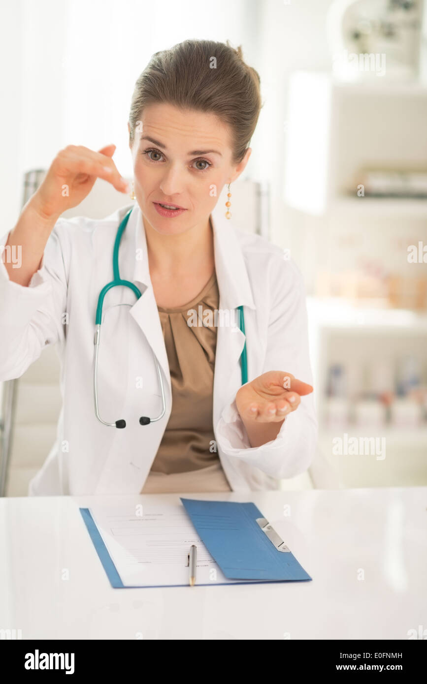 Medical doctor woman sitting in office and explaining Stock Photo - Alamy