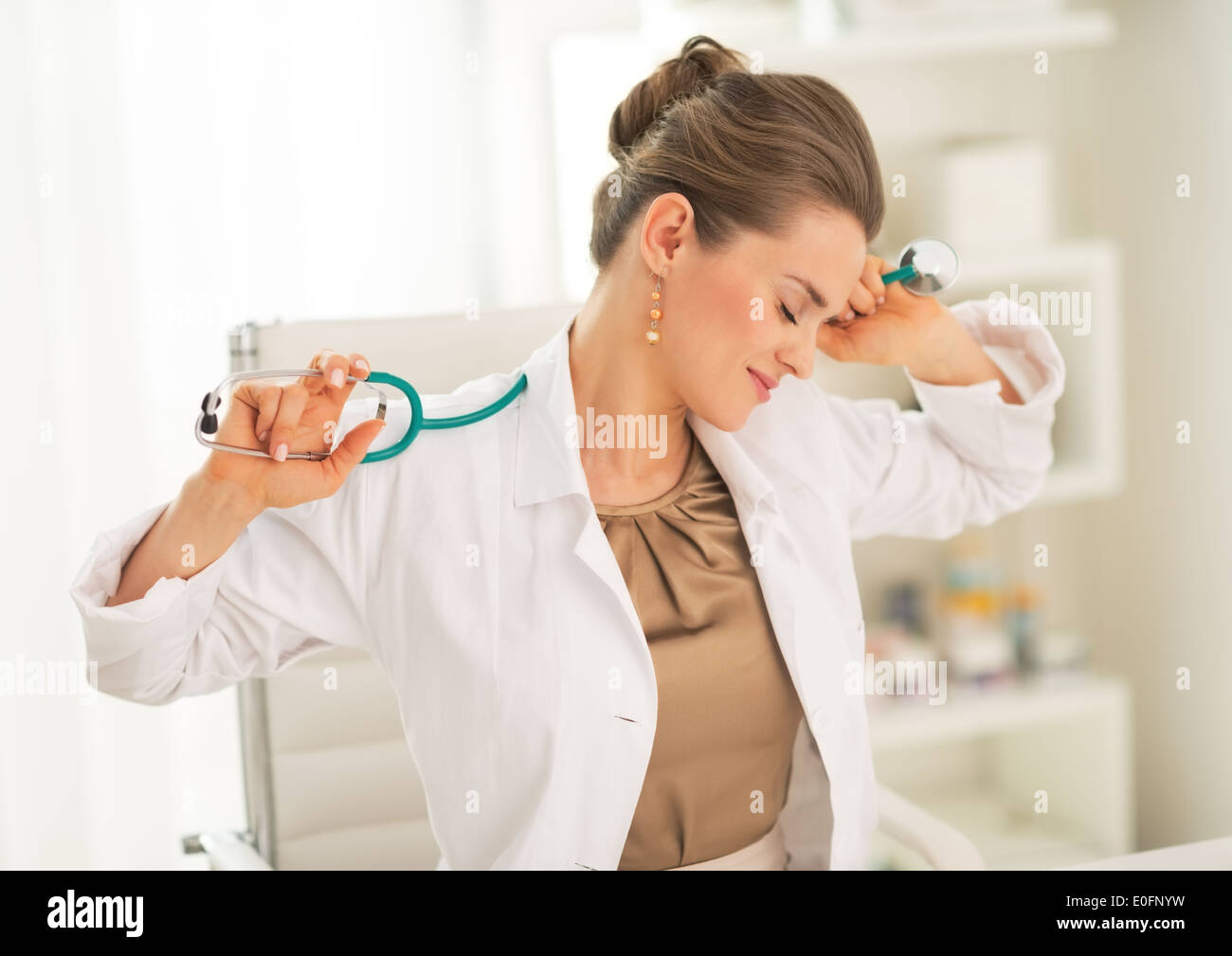 Tired medical doctor woman sitting in office Stock Photo - Alamy