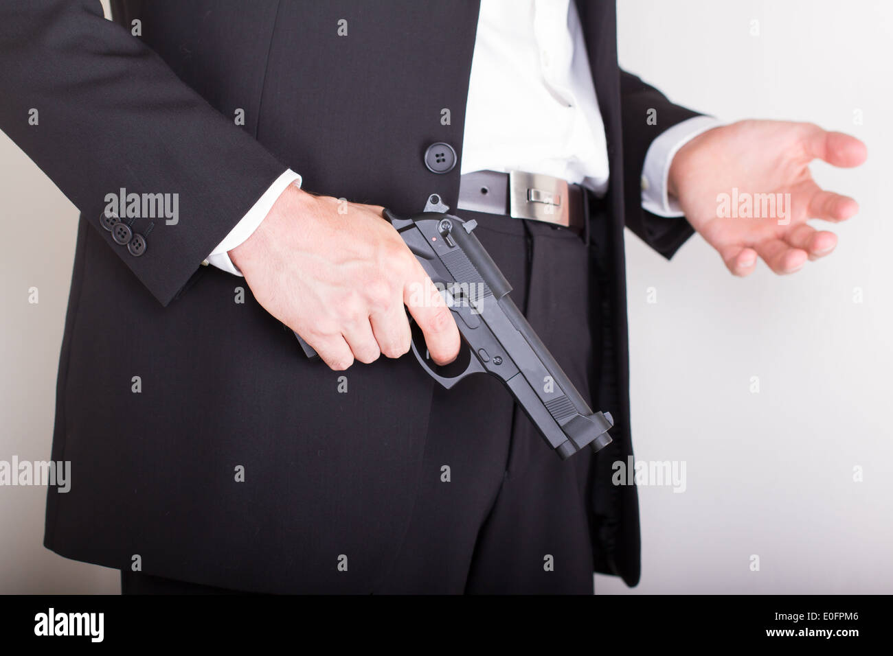 Man with gun, business suit, focus on the gun Stock Photo - Alamy