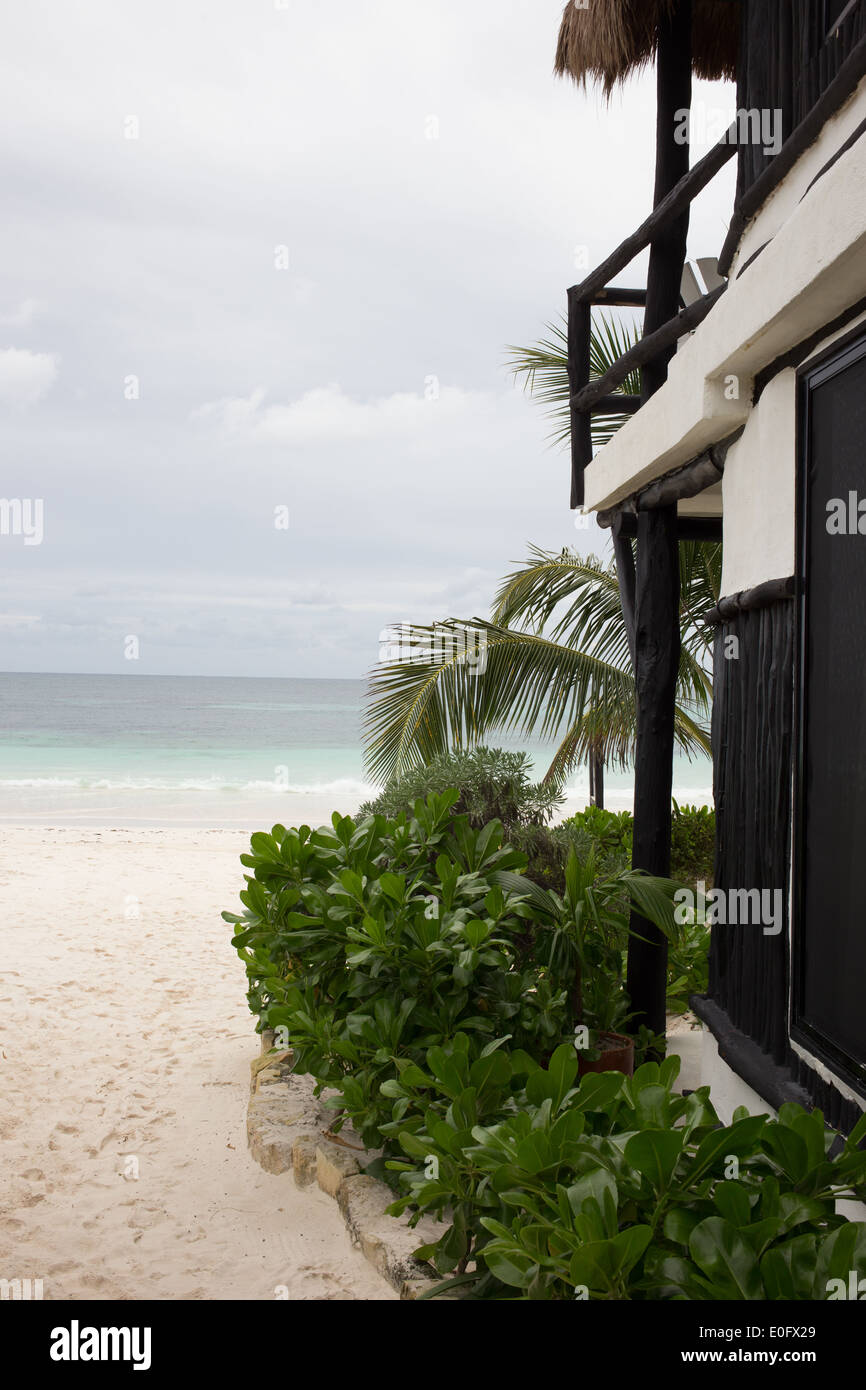 Side view of villa in Tulum facing ocean with lush greenery on the side ...