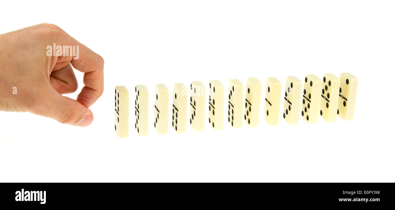 Hand ready to push dominoes in a line to cause chain reaction Stock ...