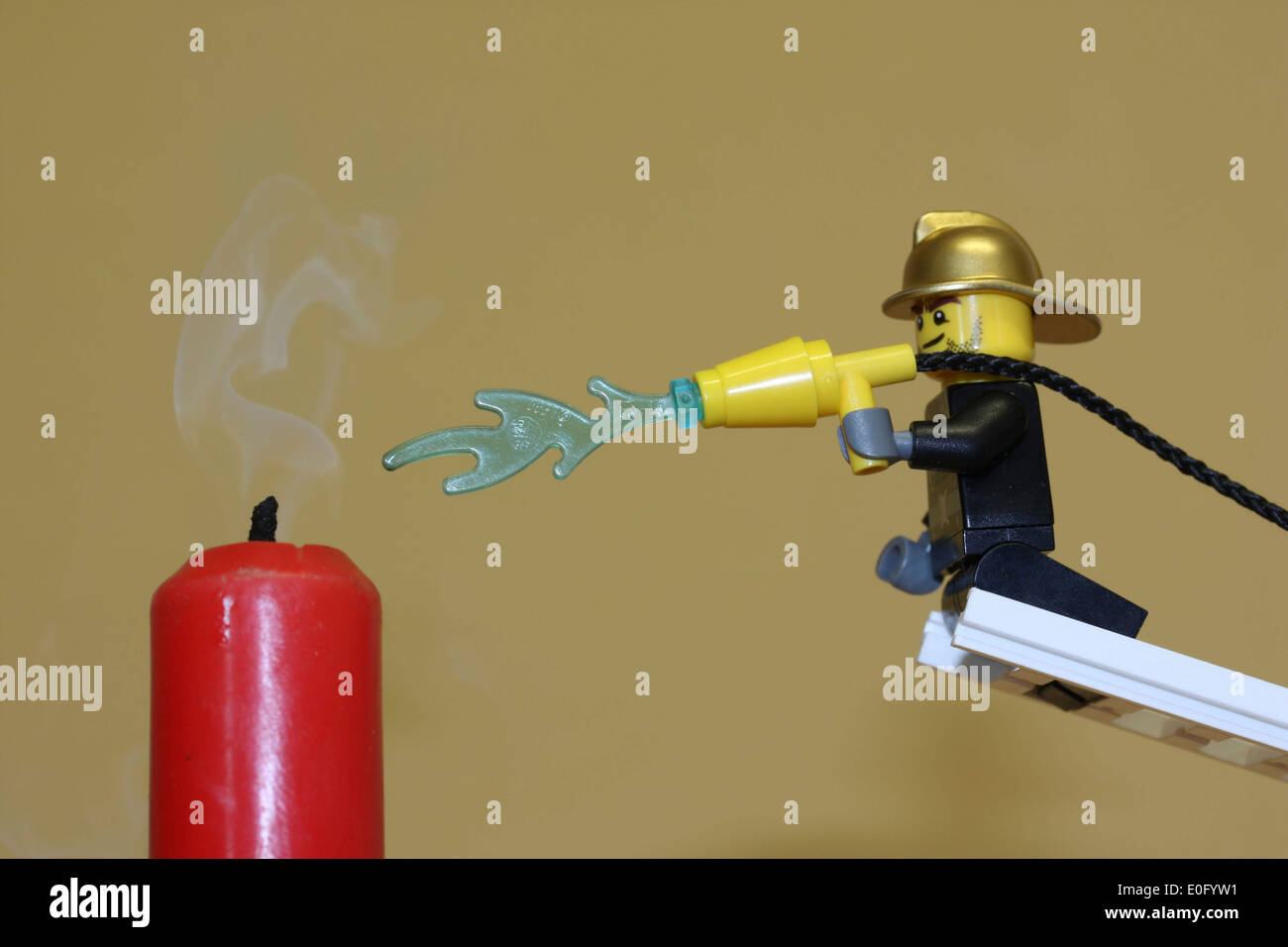 lego man firefighter who has extinguished a burning candle and left a ...