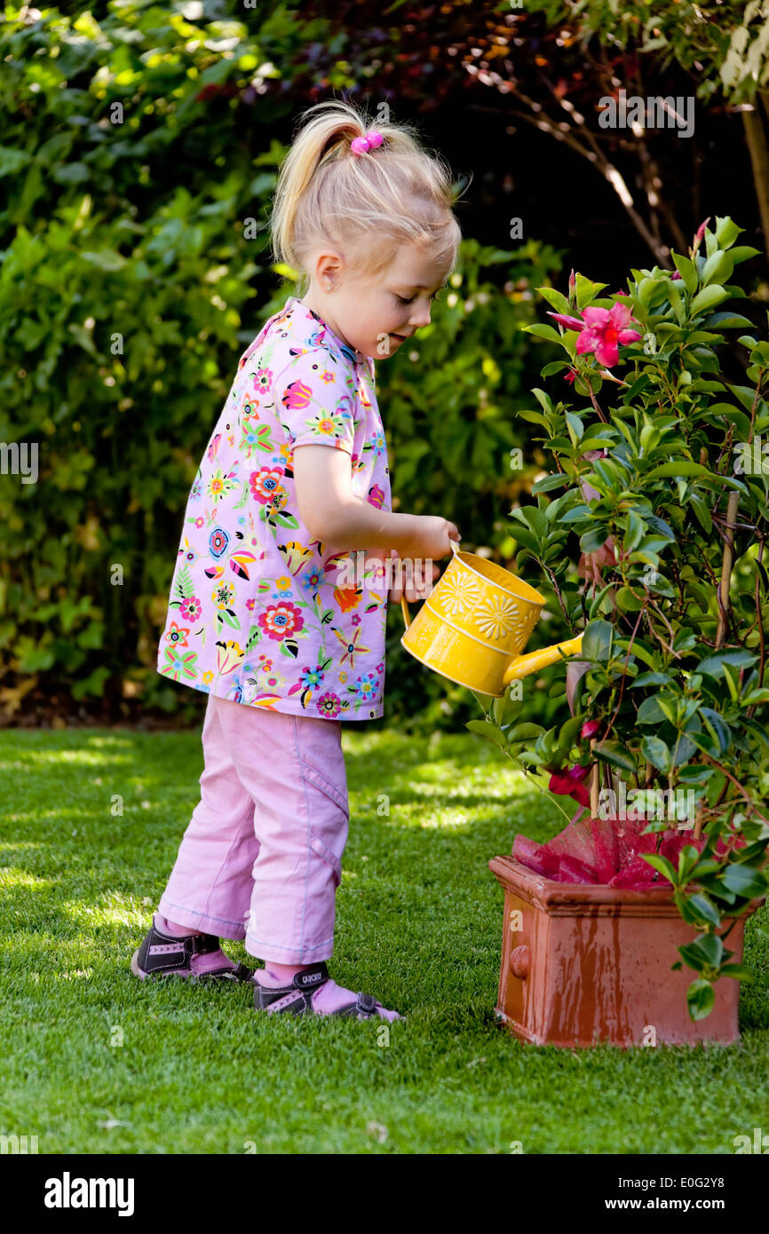 Small child with Gie ? ?kanne with the flower pour, Kleines Kind mit Gießkanne beim Blumen ...