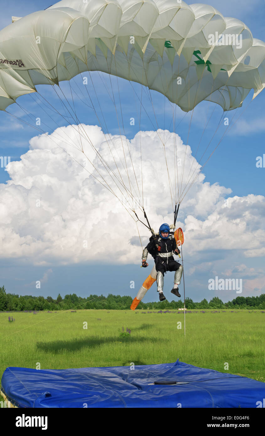 One day with parachutist in airfield. The skydiver landing under white ...