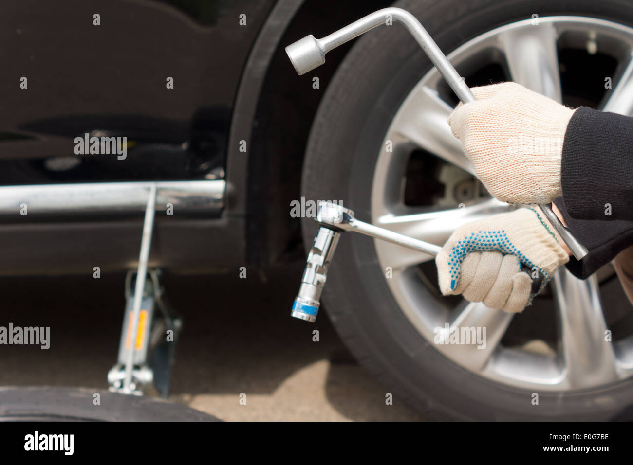 Man changing the tire on his vehicle Stock Photo - Alamy