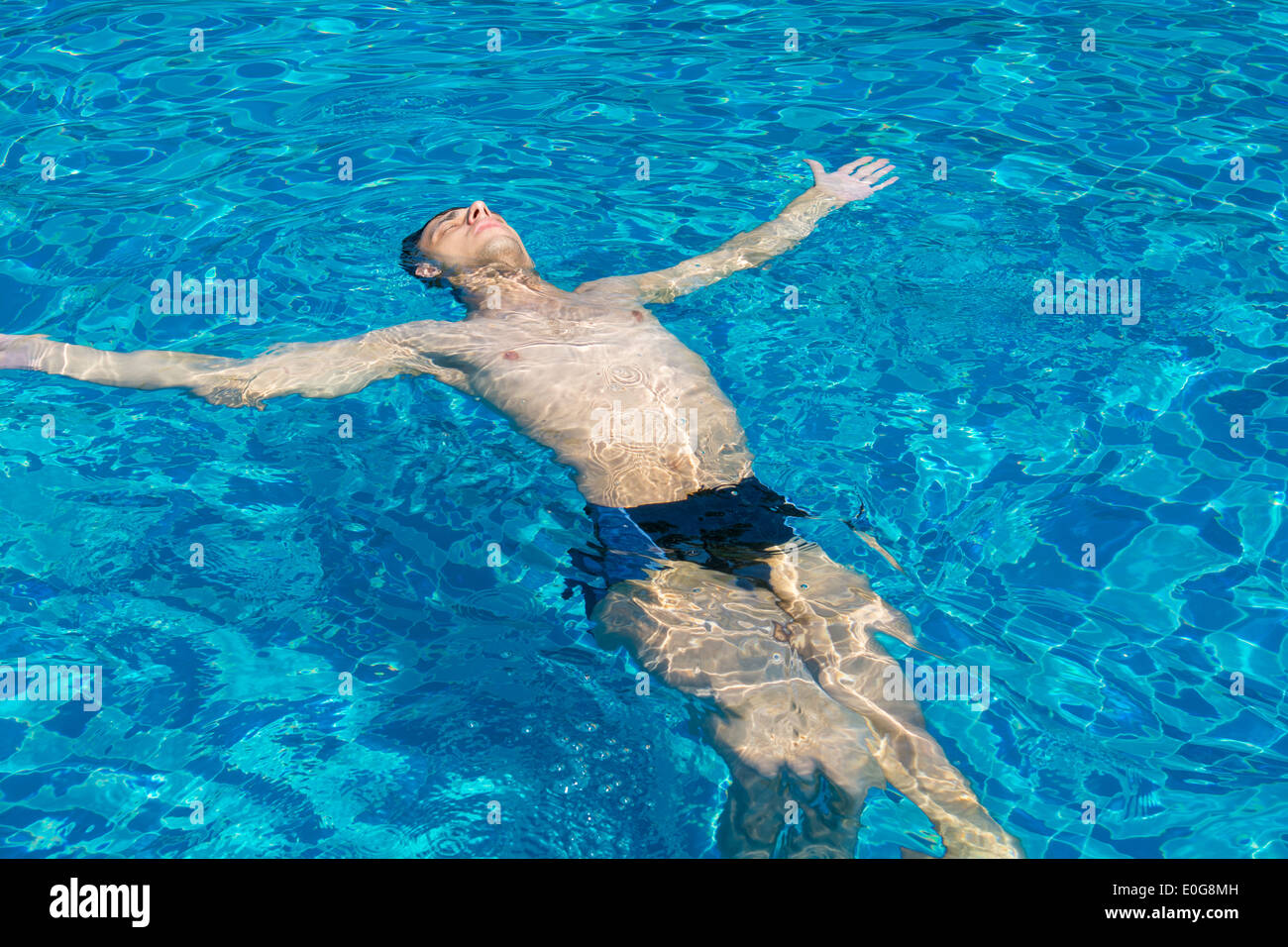 Portrait of a young man floating in the pool. Concept photo healthy ...
