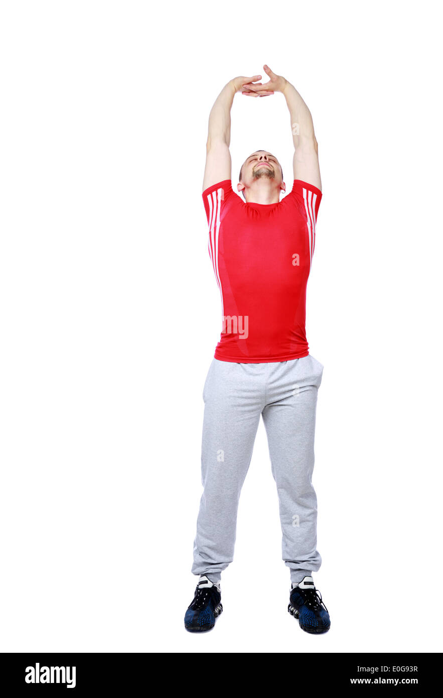 Sports man doing physical exercise for stretching over white background ...
