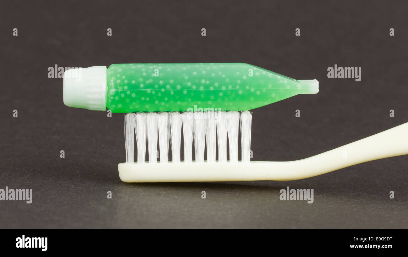 Toothbrush and green toothpaste isolated on a grey background Stock ...