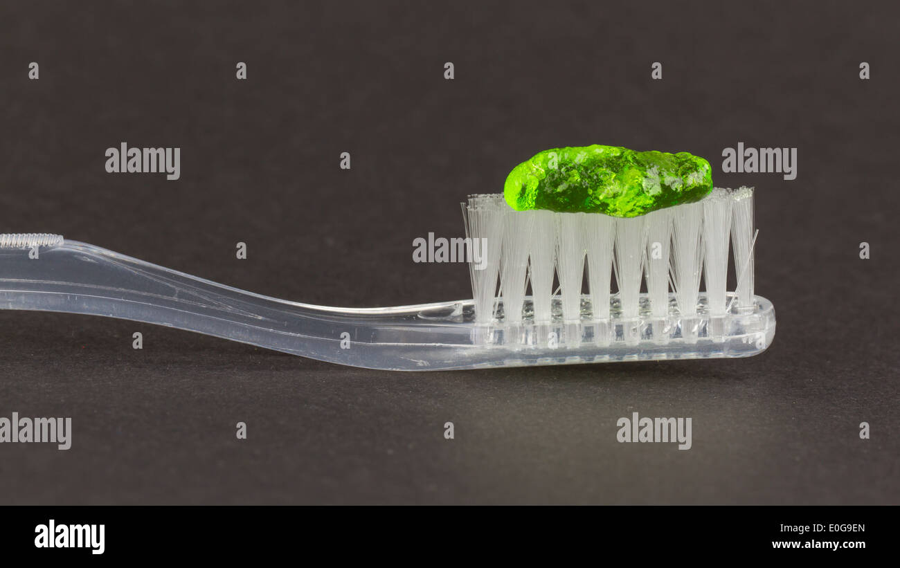 Toothbrush and green toothpaste isolated on a grey background Stock ...