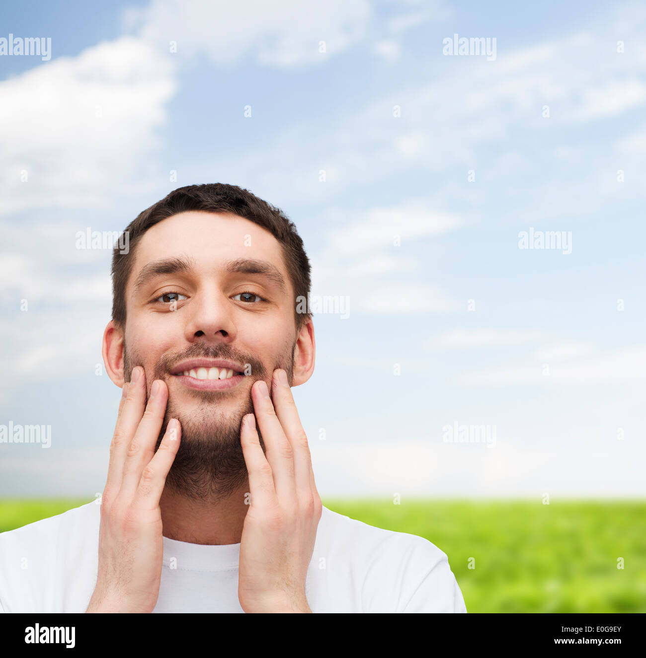 beautiful smiling man touching his face Stock Photo - Alamy