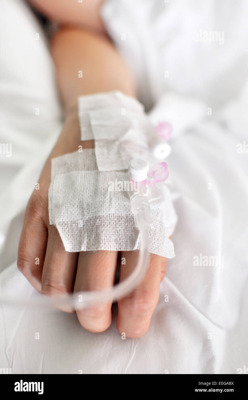 Hand of young woman with drip in hospital bed Stock Photo - Alamy