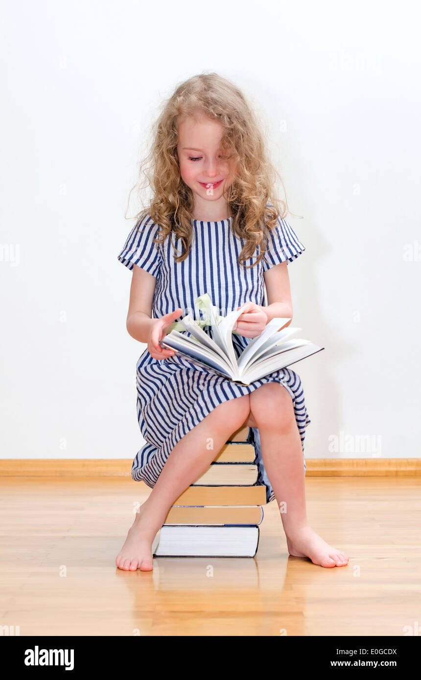 Little girl with many books at home Stock Photo - Alamy