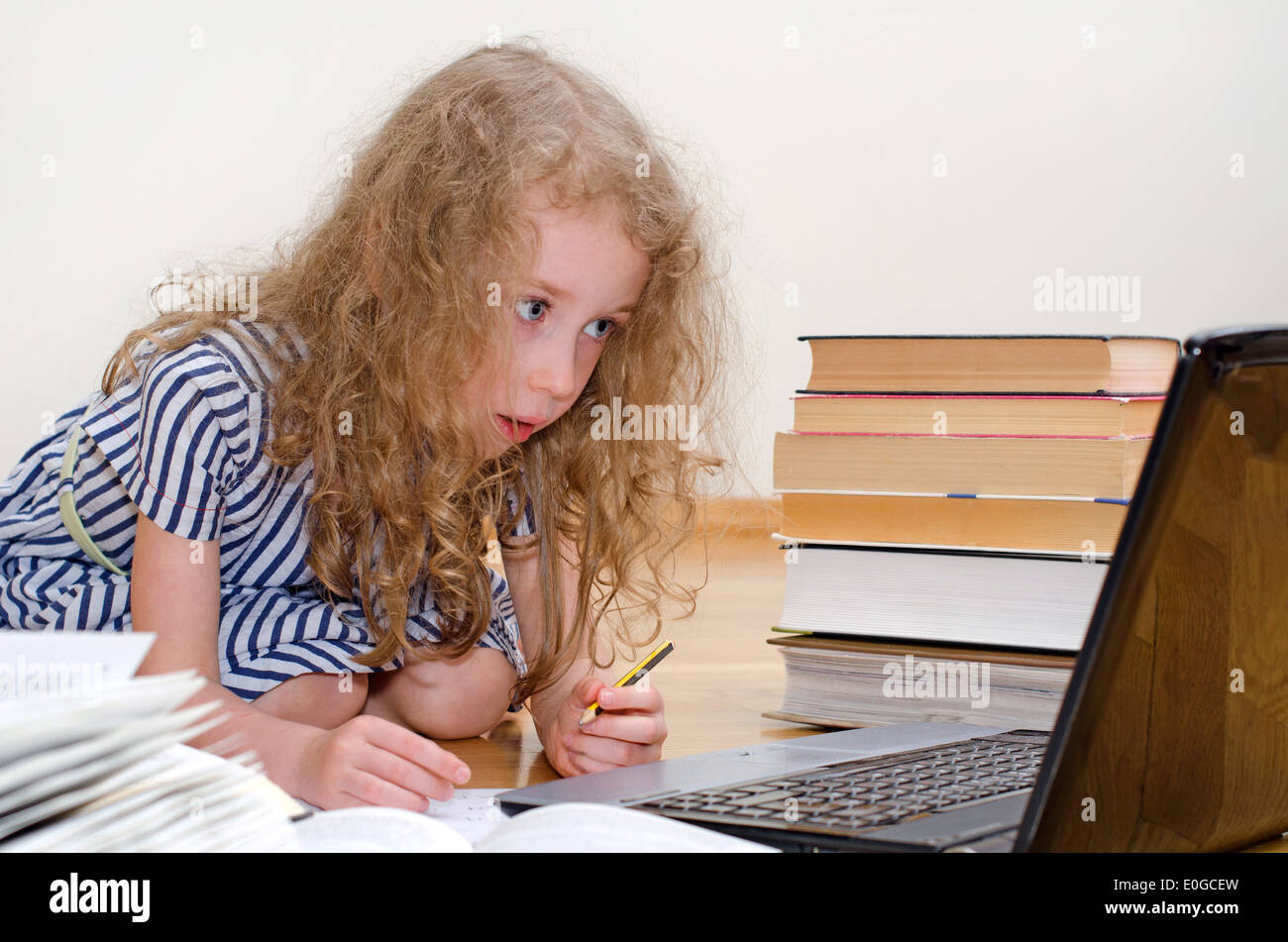 Smart little girl writes diploma at home Stock Photo - Alamy