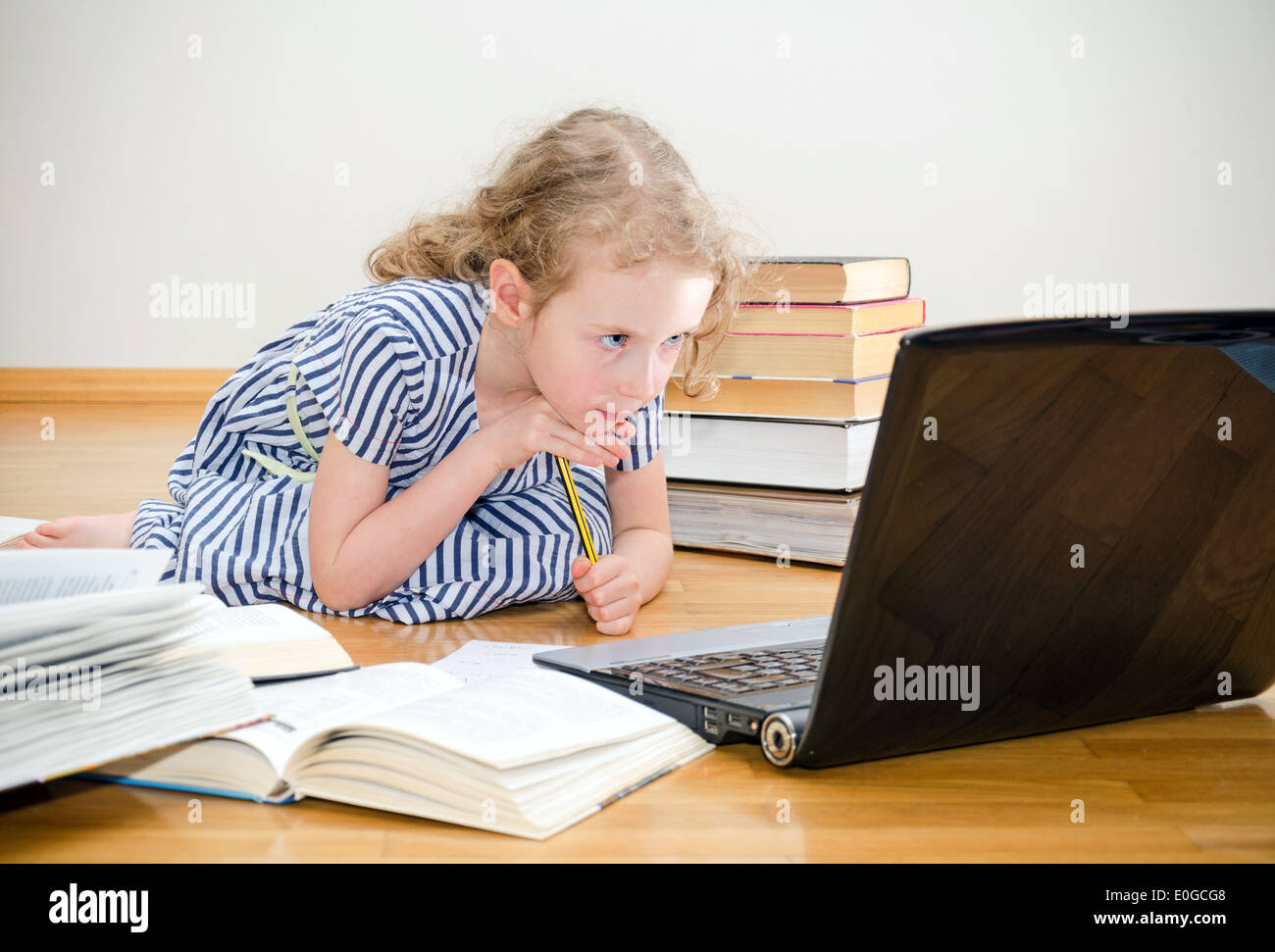 Smart little girl writes diploma at home Stock Photo - Alamy