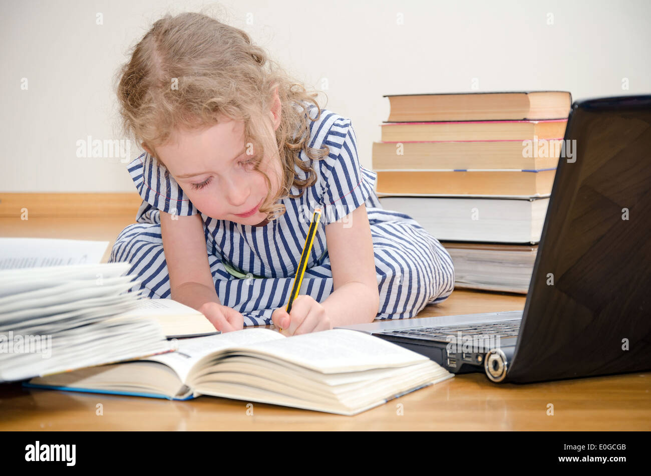 Smart little girl writes diploma at home Stock Photo - Alamy