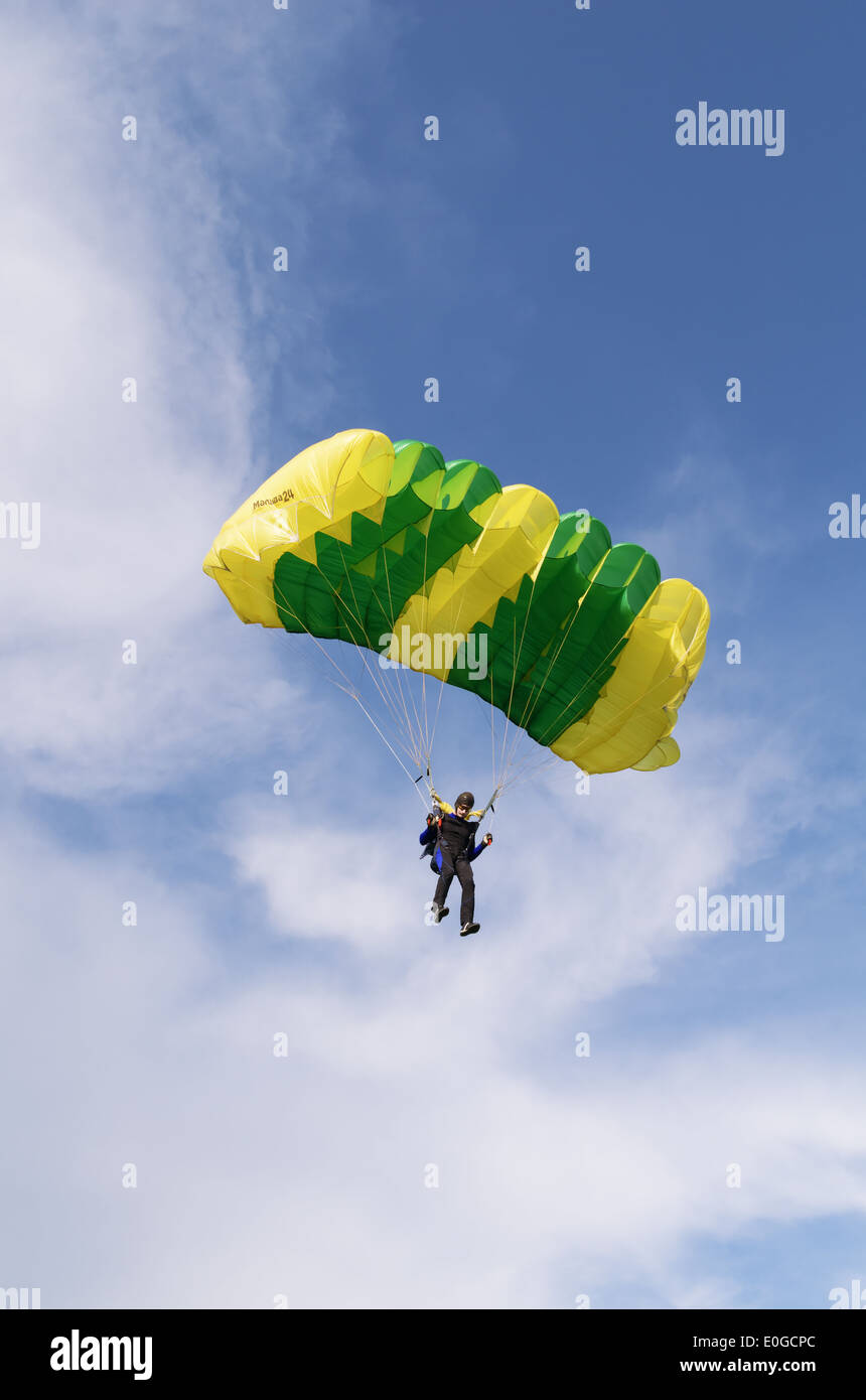 One day with parachutist in airfield. The skydiver landing under green ...