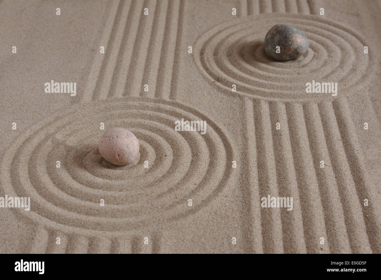 two stones on a sand background Stock Photo - Alamy