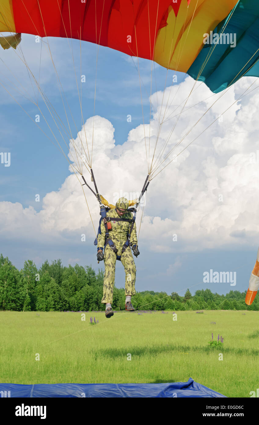 One day with parachutist in airfield. The skydiver landing under green ...
