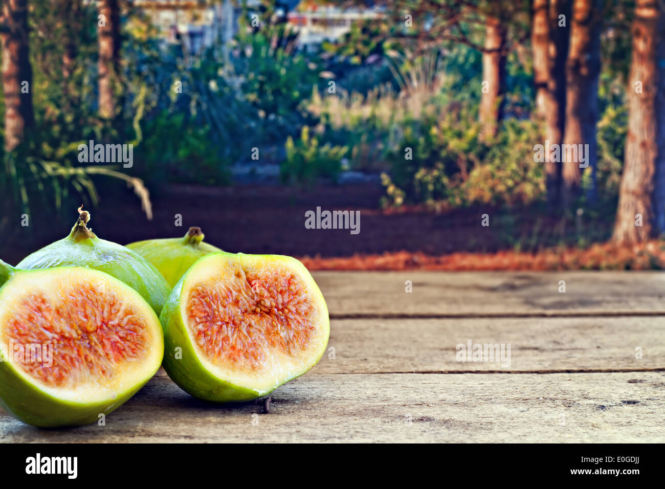 Fresh figs on rustic wooden table against forest background Stock Photo ...