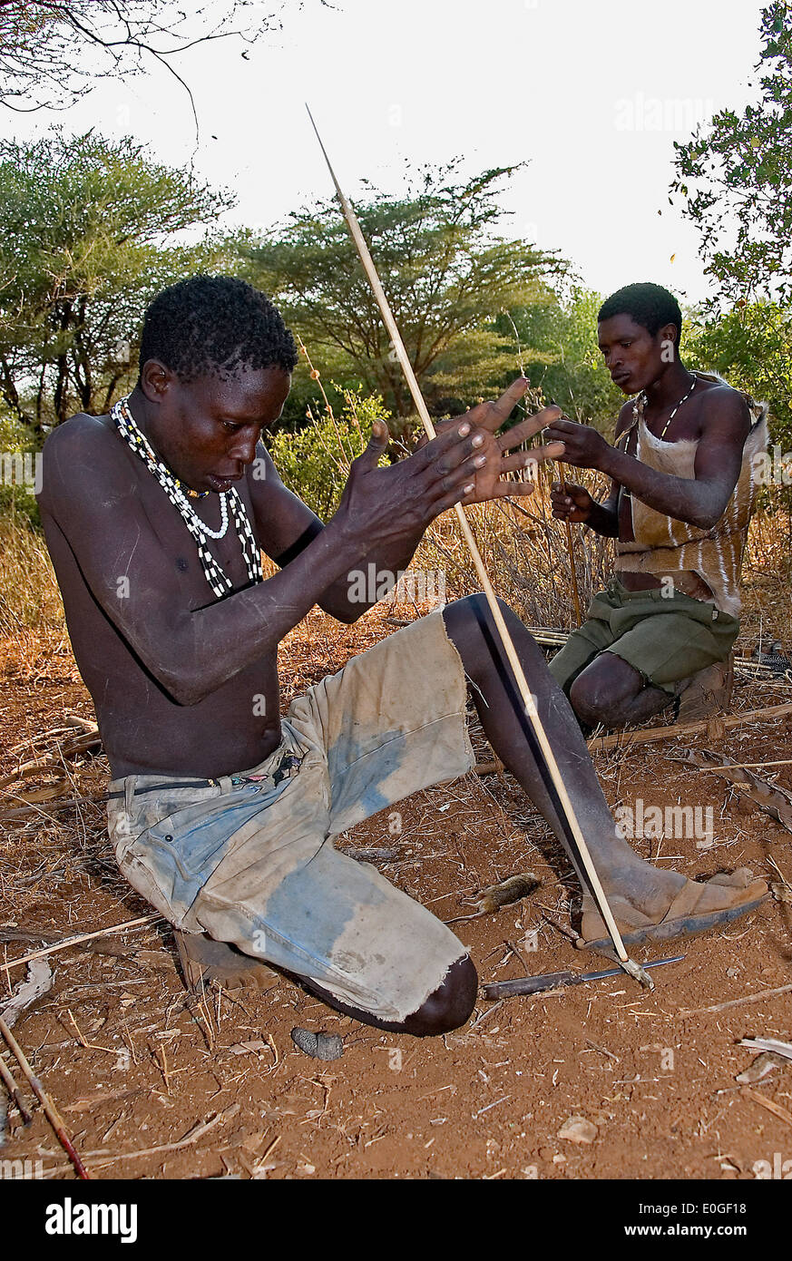 Hadzabe bushman making up fire with sticks. Brine Eyasi, northern ...