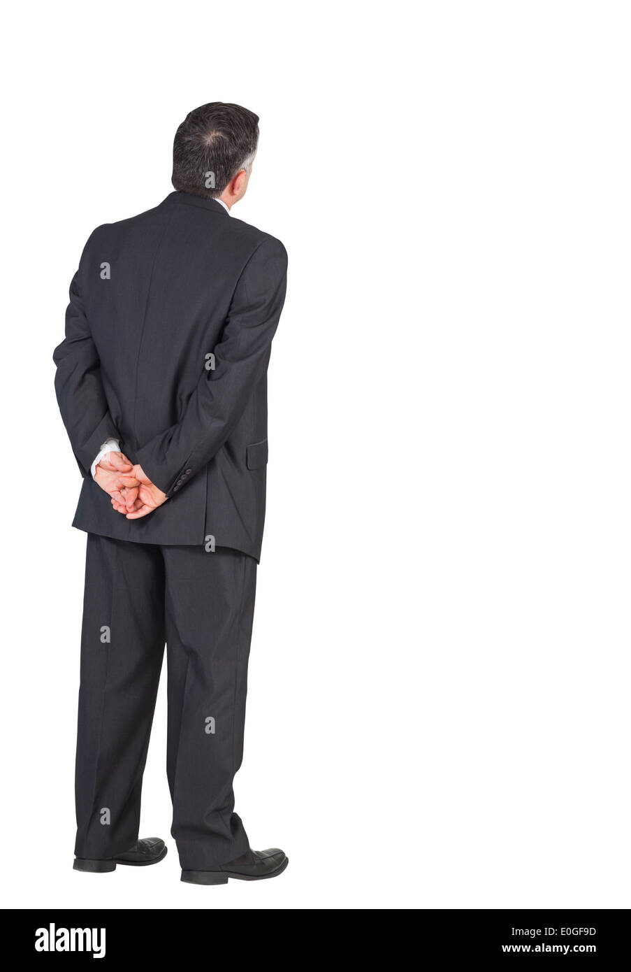 Mature businessman standing with hands behind back Stock Photo - Alamy
