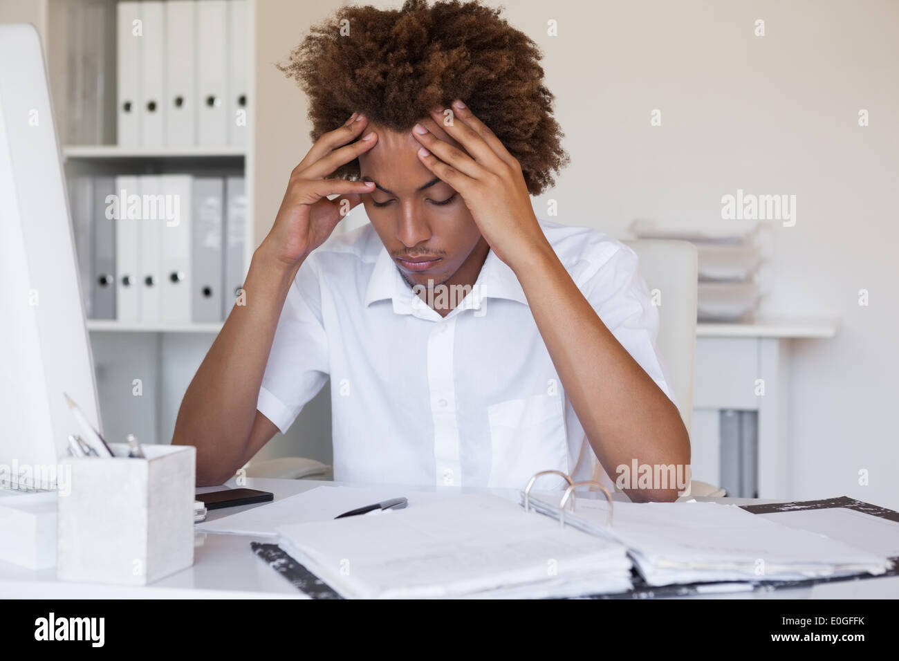 Casual stressed businessman with his head down at desk Stock Photo - Alamy