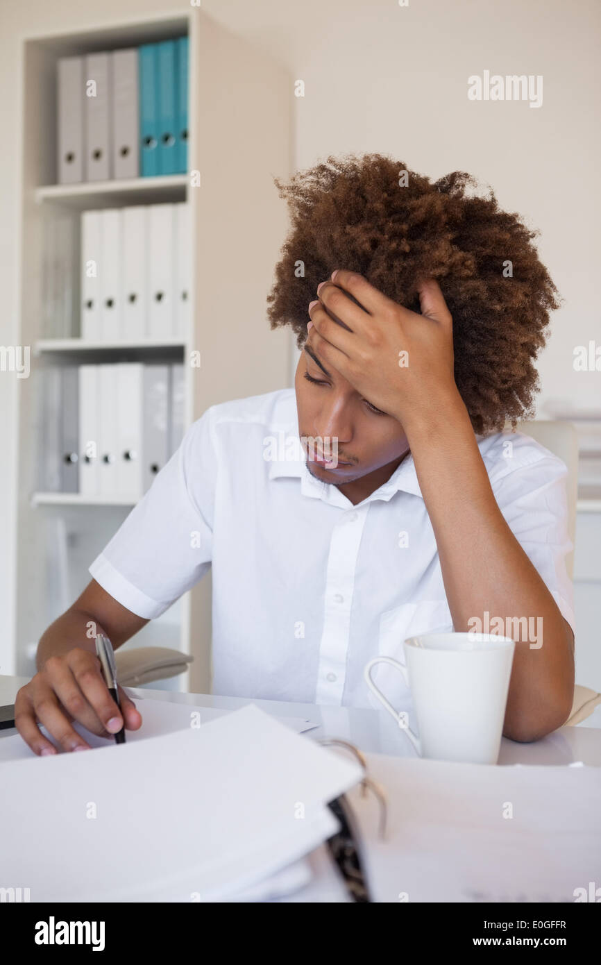 Casual stressed businessman writing at his desk Stock Photo - Alamy