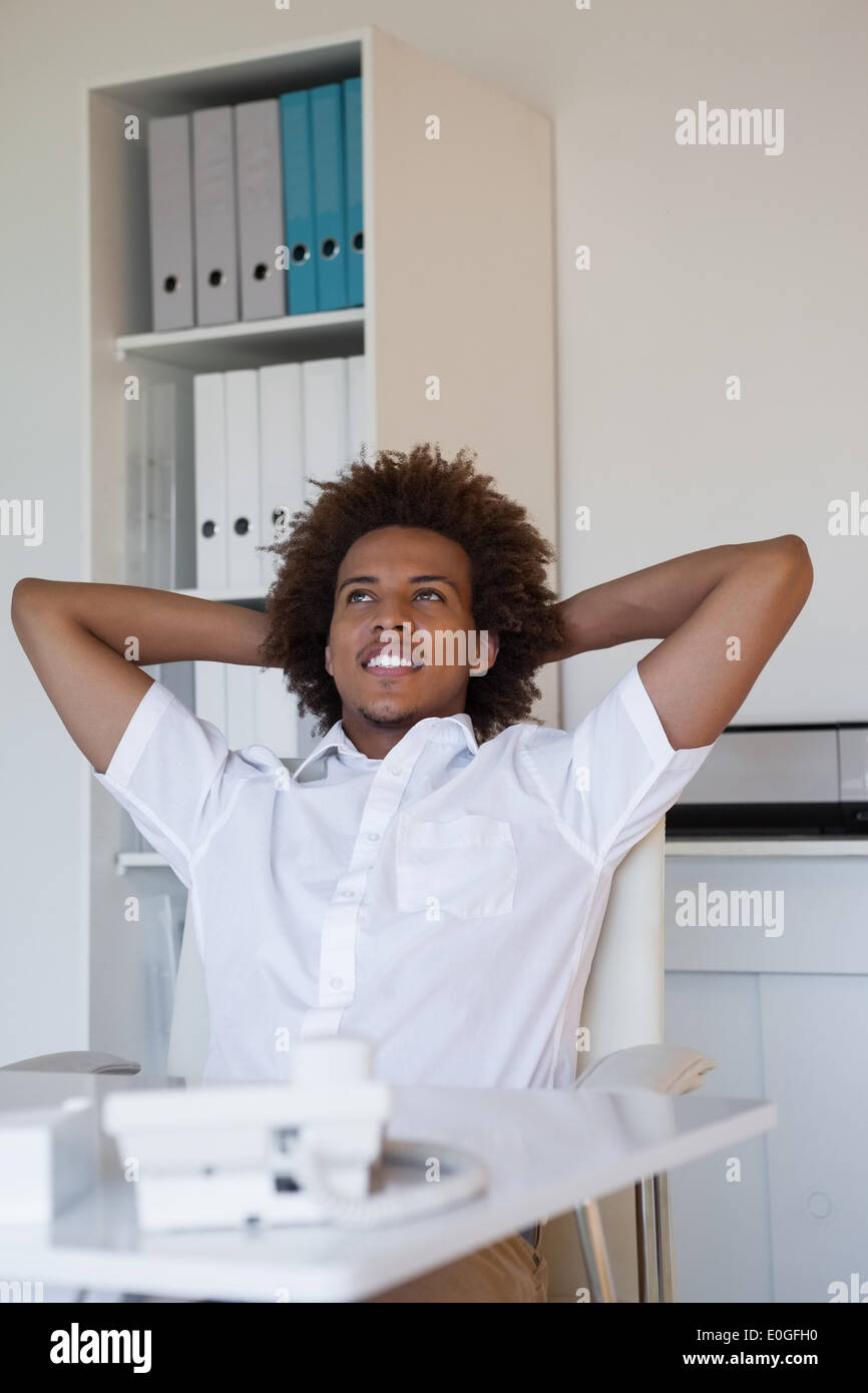 Relaxed casual businessman leaning back at his desk Stock Photo - Alamy