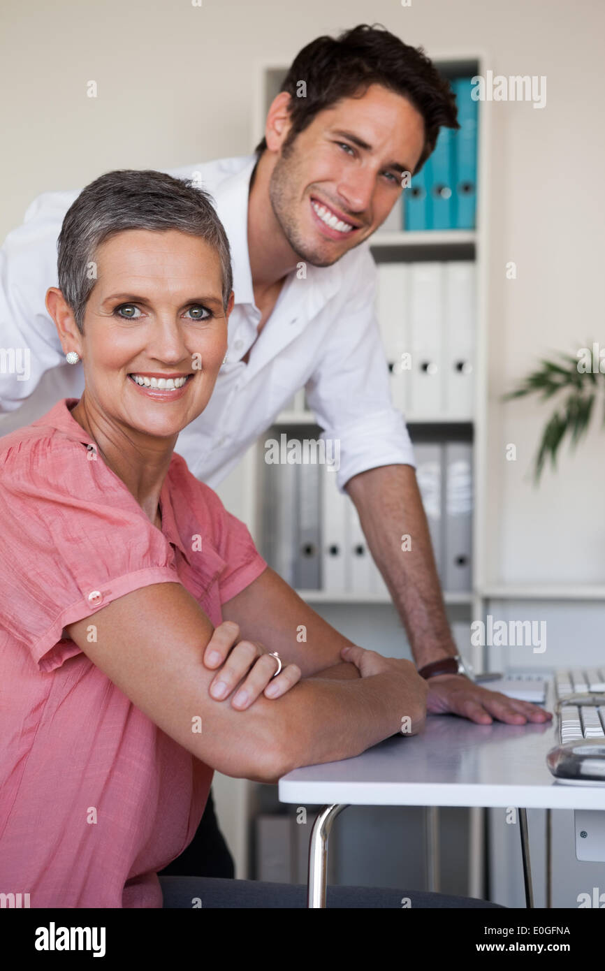 Casual business team working together at desk using computer Stock ...